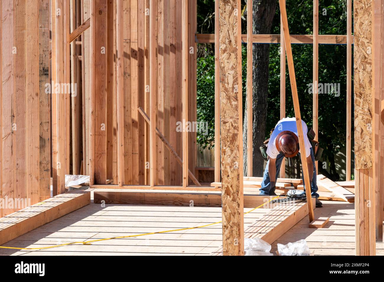 Construction worker in toolbelt and hard hat working with a pneumatic ...