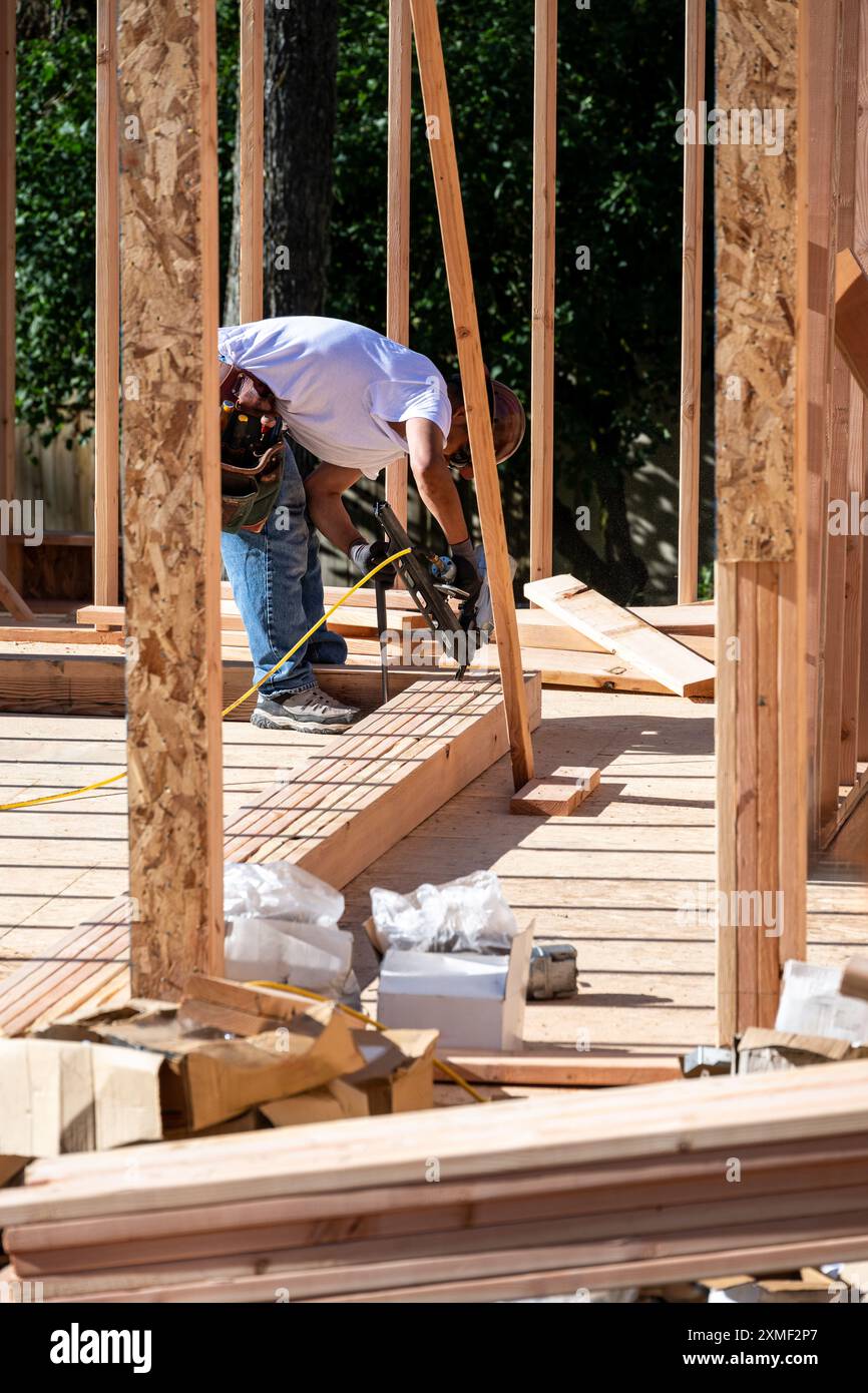 Construction worker in toolbelt and hard hat working with a pneumatic ...