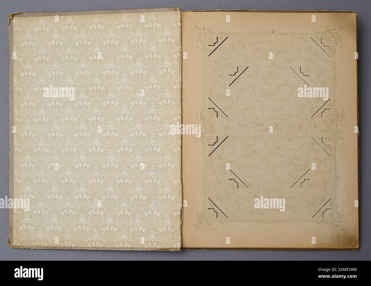 This image depicts an open vintage photo album with ornate decorative ...
