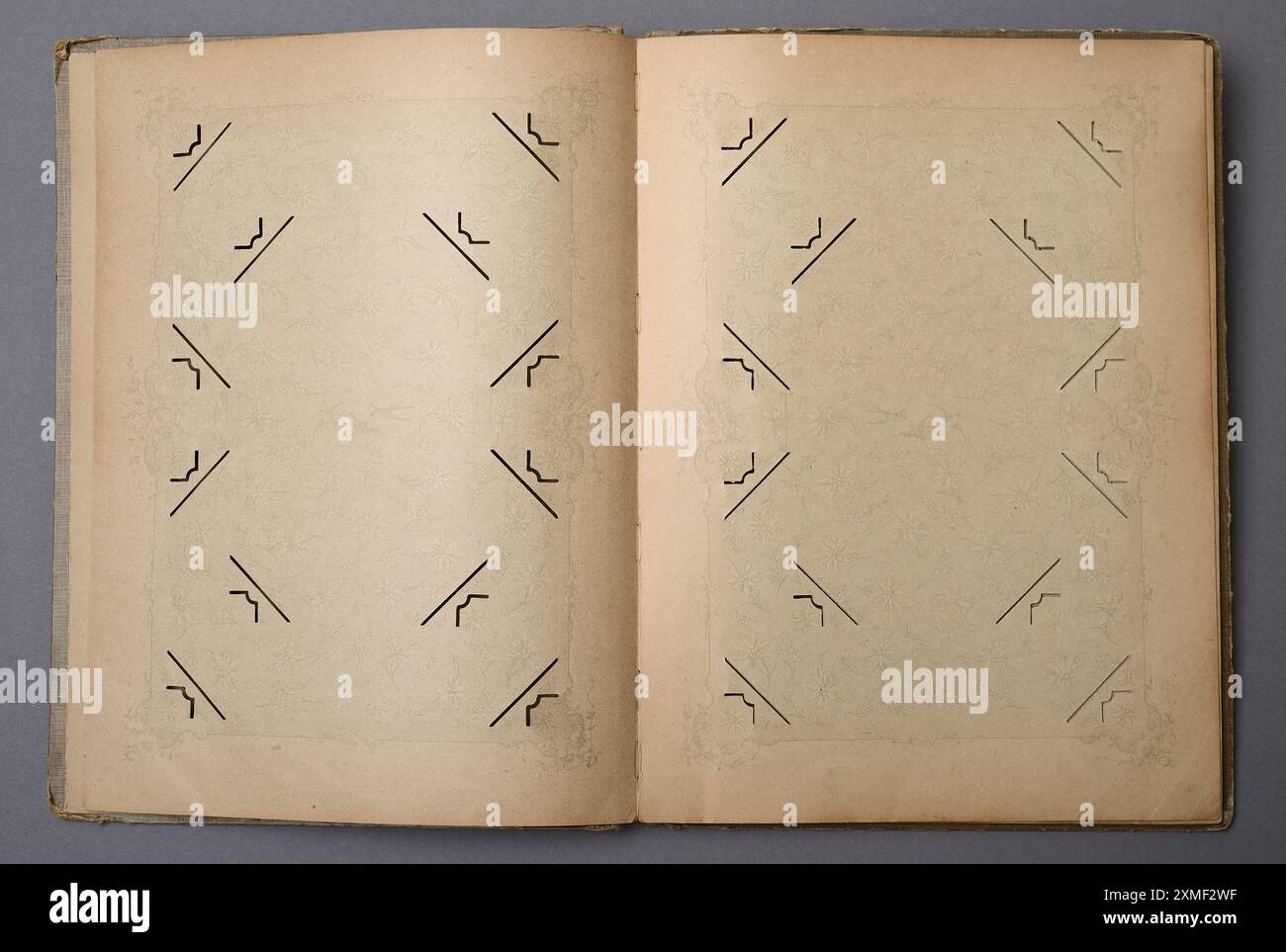 This image shows an open vintage photo album with two blank pages ...