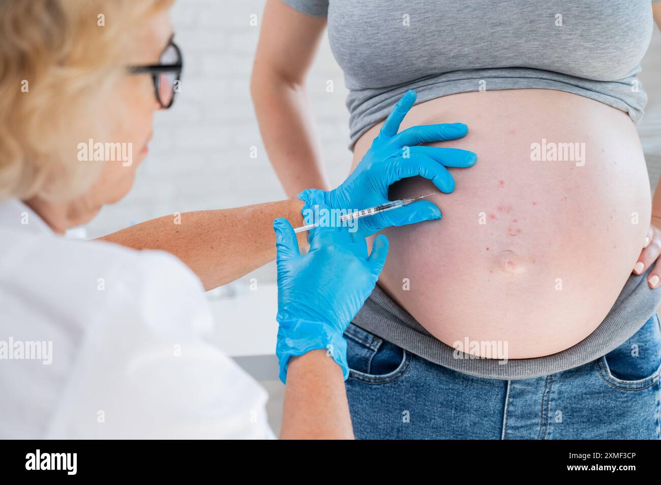 Doctor gives an injection in the stomach of a pregnant woman Stock ...