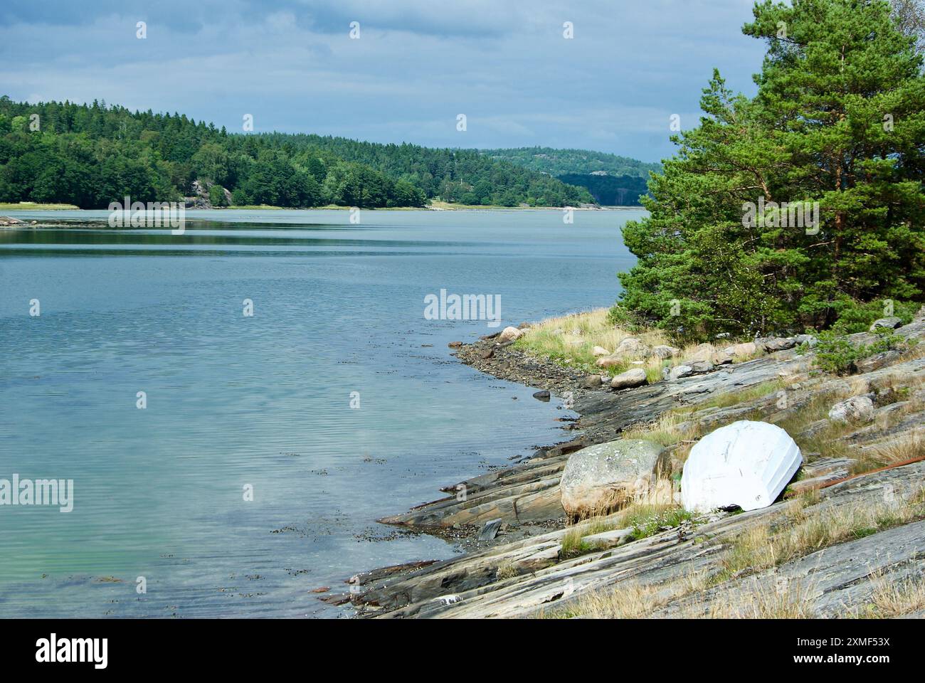Coastal landscape with a white boat laying upside down on a bathing ...