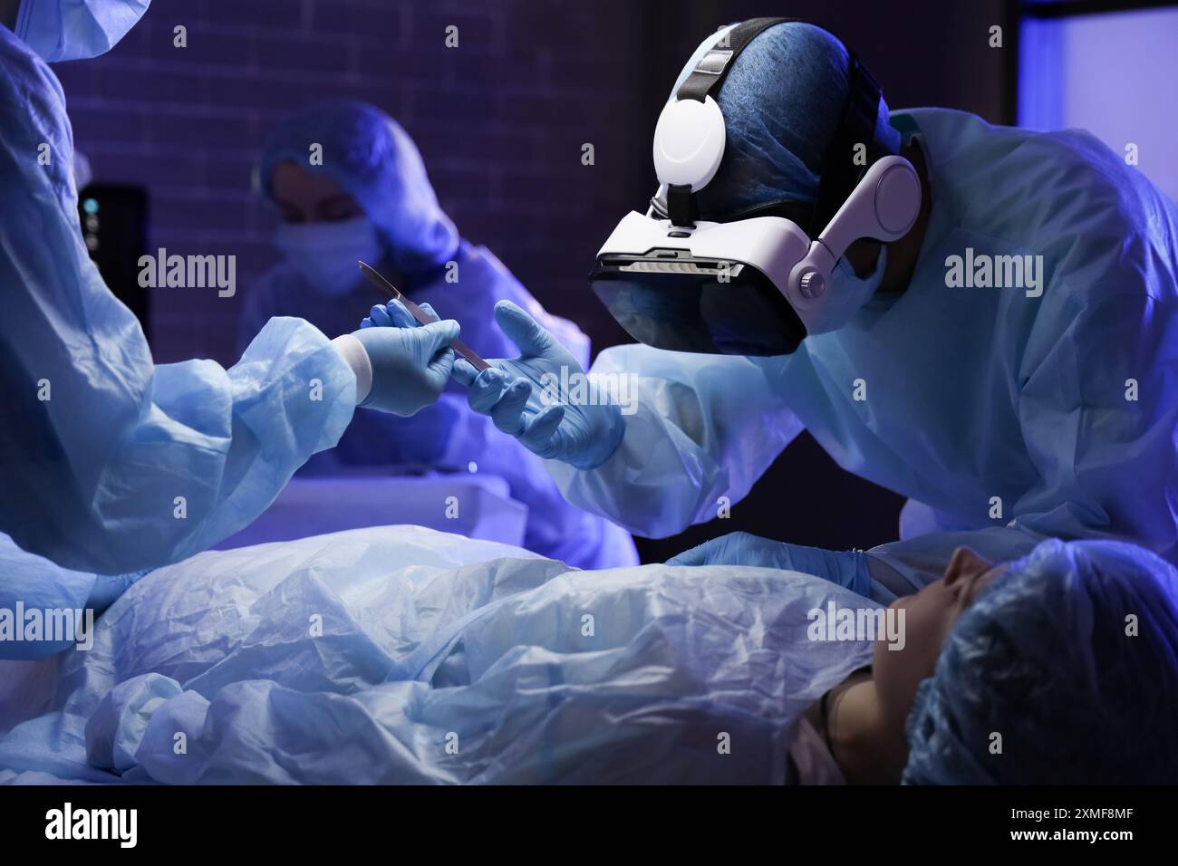 Surgeon with VR glasses taking scalpel from nurse in operating room ...