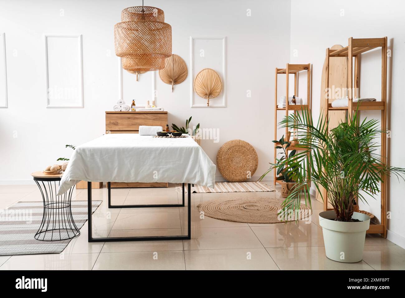 Interior of light spa salon with massage couch, fans and shelf units ...