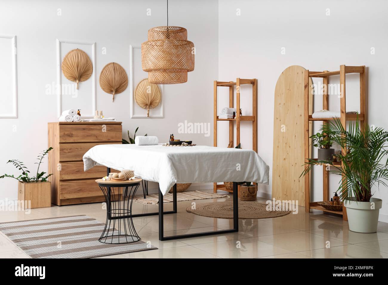 Interior of light spa salon with massage couch, fans and shelf units ...