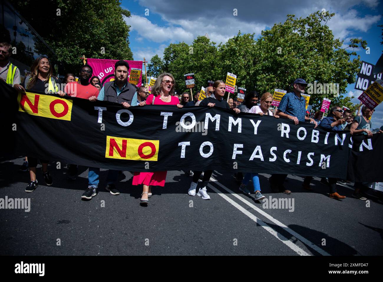 Protestors march with a large banner during the demonstration. Tommy ...