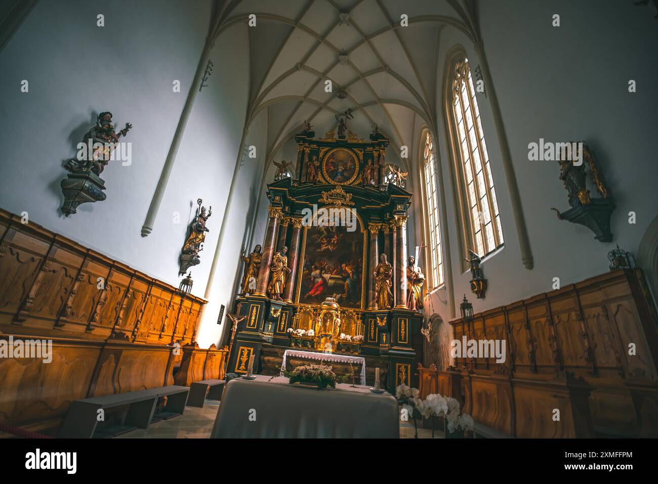 Austria - October 26, 2023 : An ornate, golden altar inside a dimly lit ...