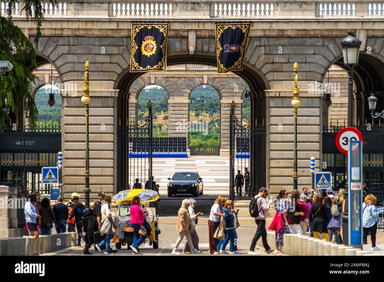 Madrid cityscape with the Royal Palace gates open for a black car after ...