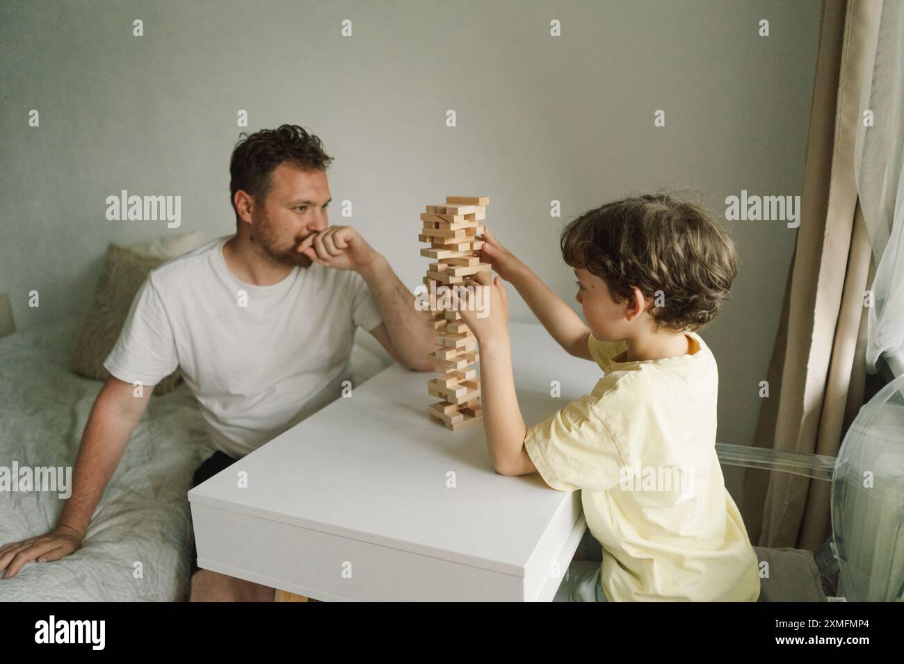 Father and Son Play Block Tower Game Indoors During Daytime Stock Photo ...