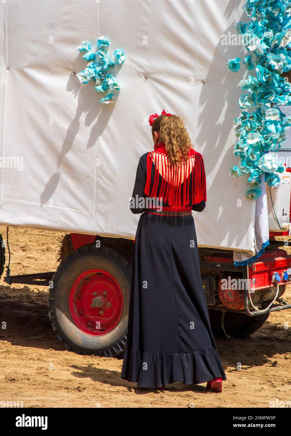 Woman turned wearing the typical "rociero" costume and flowers in her ...