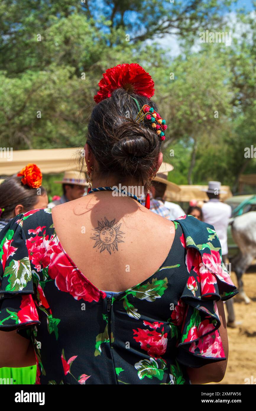 Woman turned wearing the typical "rociero" costume and flowers in her ...