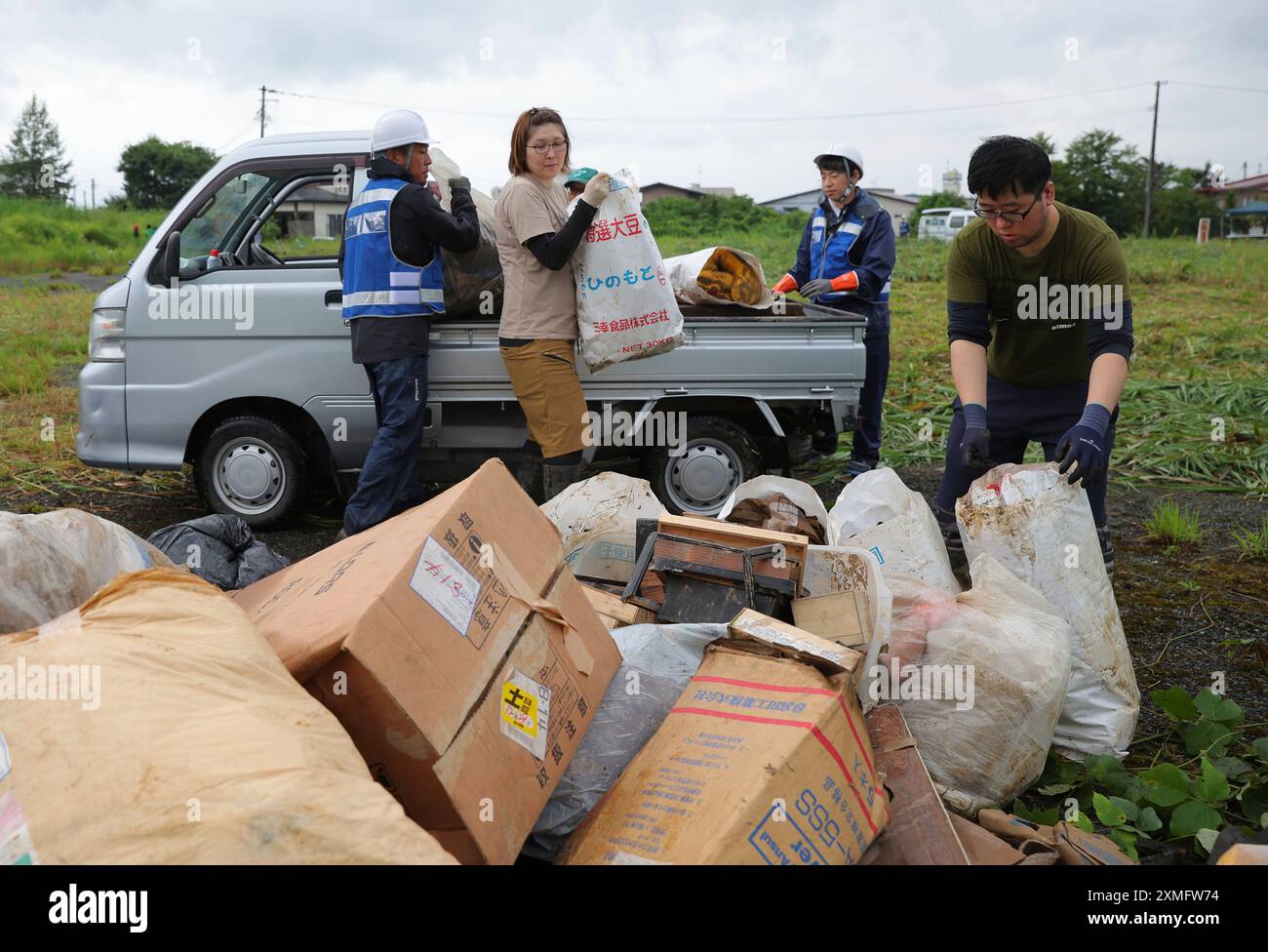 Local residents and city officials unload disaster waste generated by ...