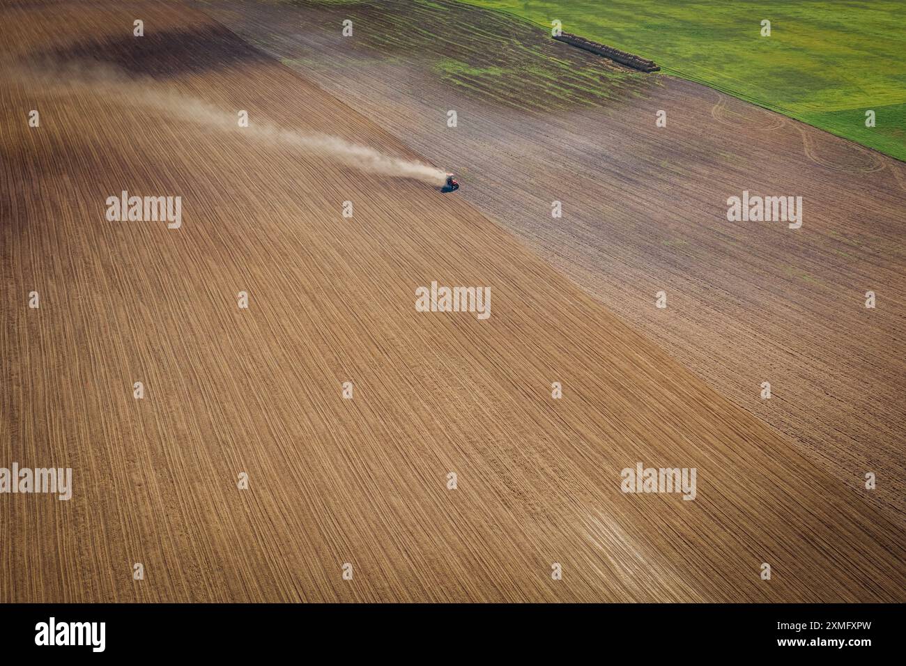 Aerial view of an Agricultural Field with a Tractor plowing land for ...