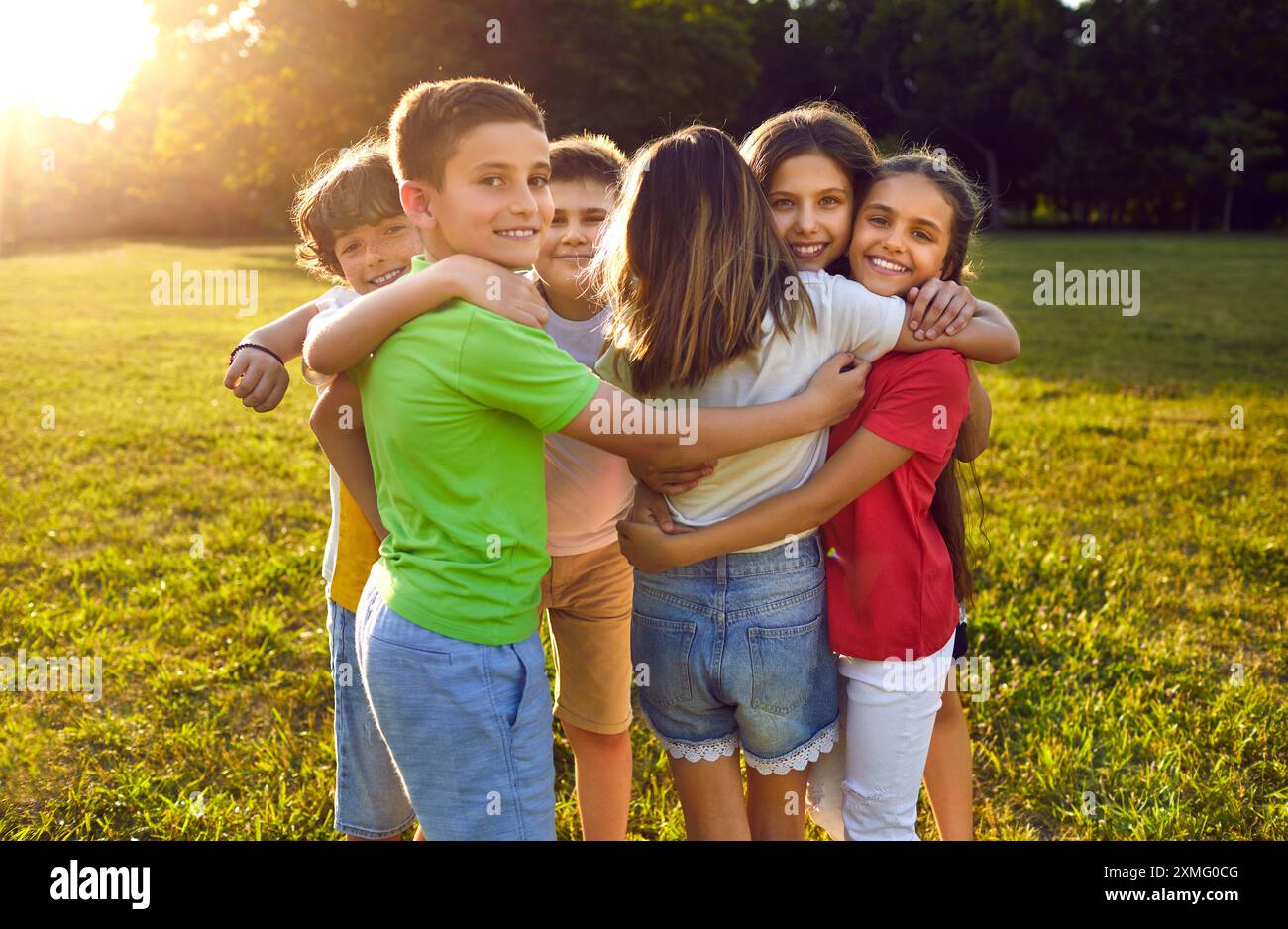 Happy friendly teenagers girls and boys hugging smiling turning to ...
