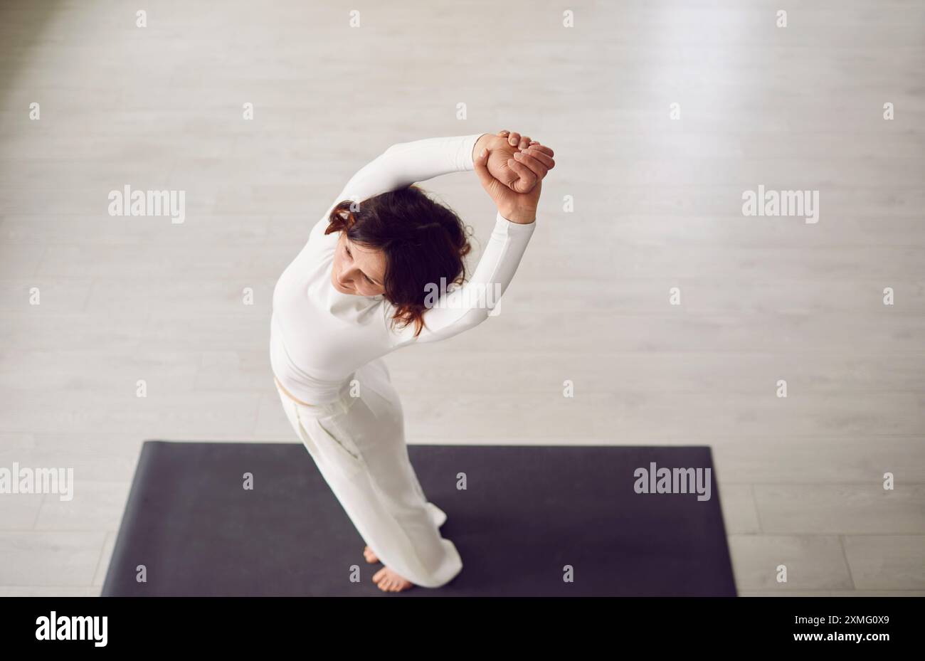 Attractive sporty yogi woman working out stretching warm up, top view ...