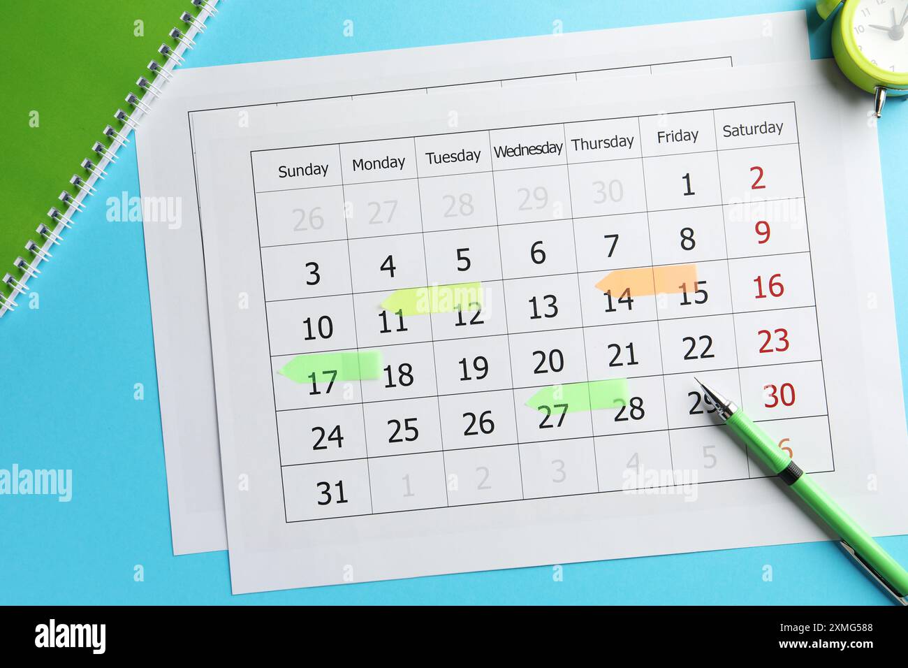 Timetable. Calendar page with marked dates, pen, alarm clock and ...