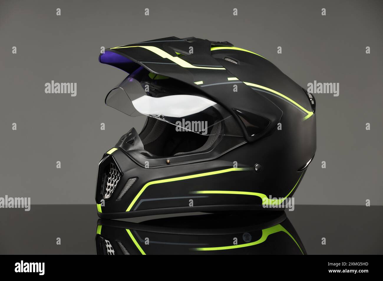 Modern motorcycle helmet with visor on mirror surface against light ...