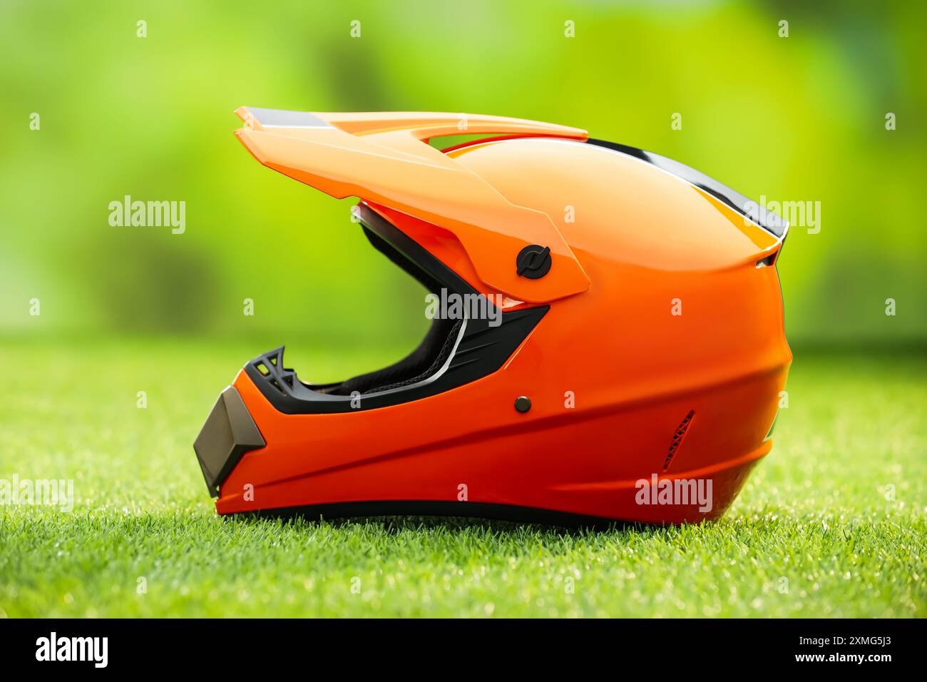 Orange motorcycle helmet with visor on green grass Stock Photo - Alamy