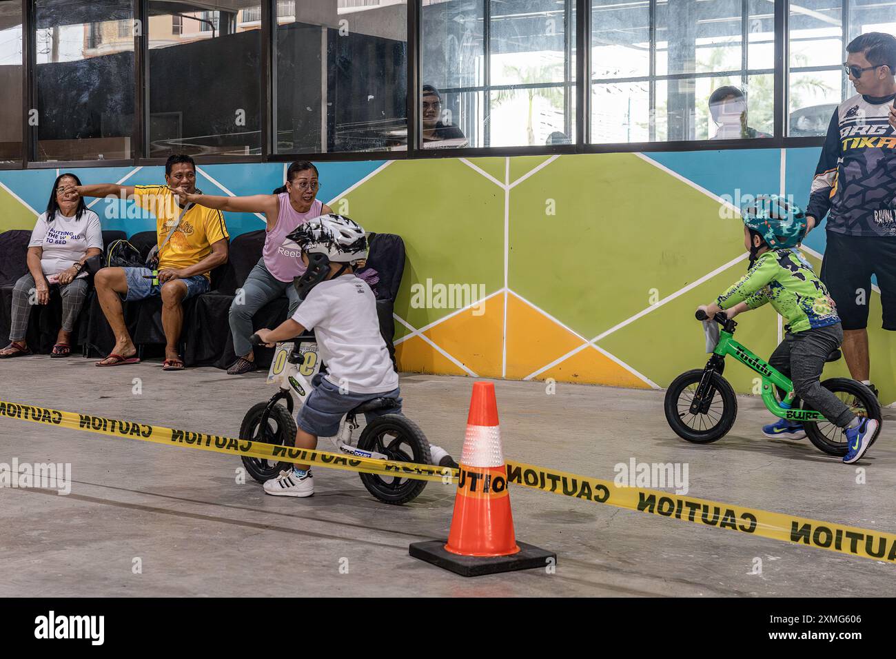 Iloilo City, Philippines. 28th July, 2024. Parents coach their children during a push bike race ...