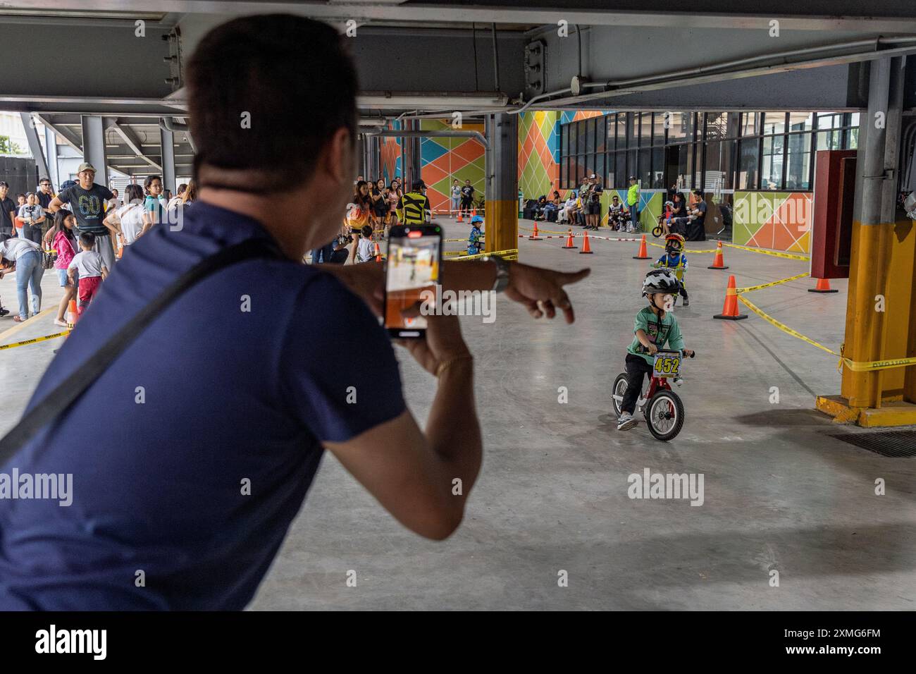 Iloilo City, Philippines. 28th July, 2024. A father coaches his child during a push bike race ...