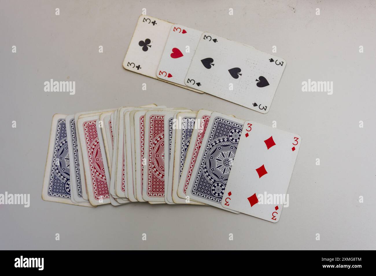 some playing cards on a table showing the number three Stock Photo - Alamy