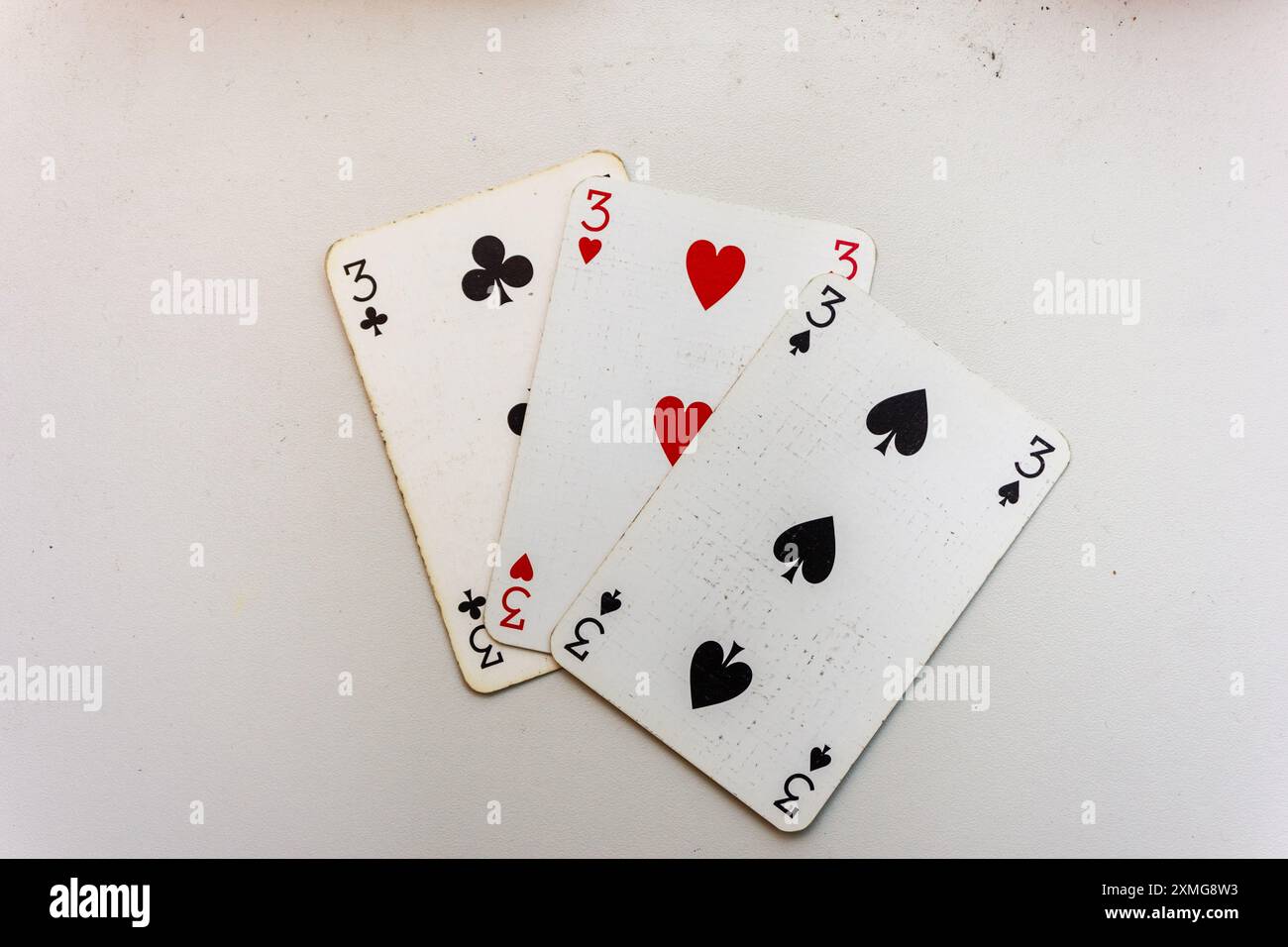 some playing cards on a table showing the number three Stock Photo - Alamy