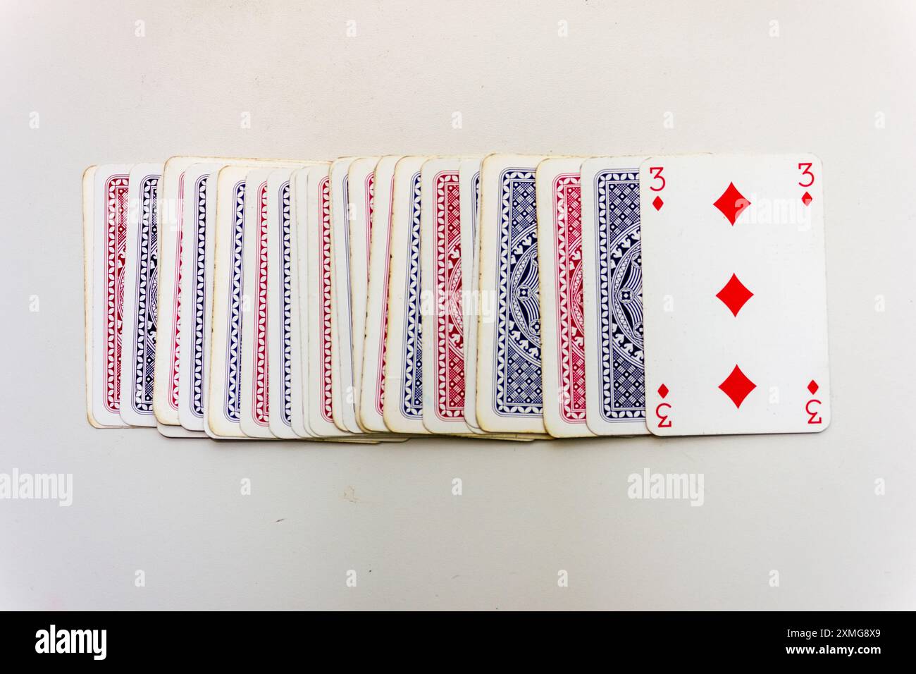 some playing cards on a table showing the number three Stock Photo - Alamy