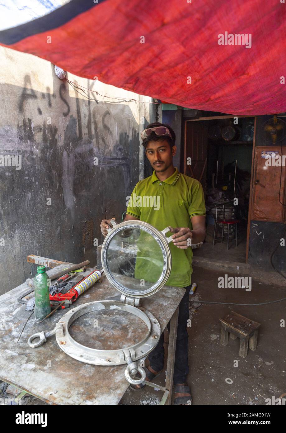 Bangladeshi worker with a porthole at Dhaka Shipyard, Dhaka Division ...
