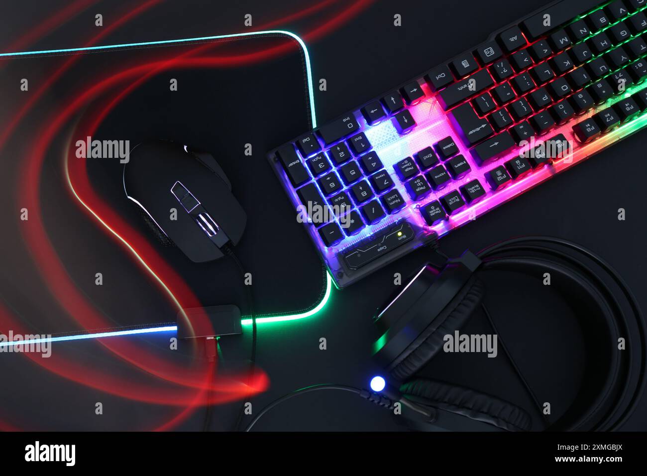 Computer mouse, RGB keyboard and headset in neon lights on black ...