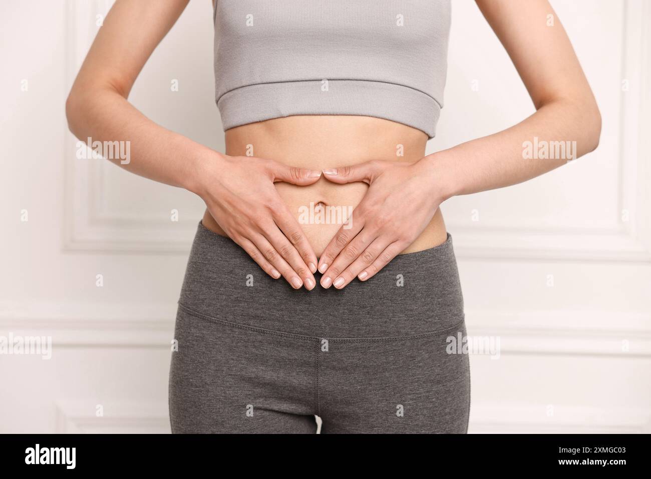 Healthy digestion. Woman making heart shape with hands near her belly ...