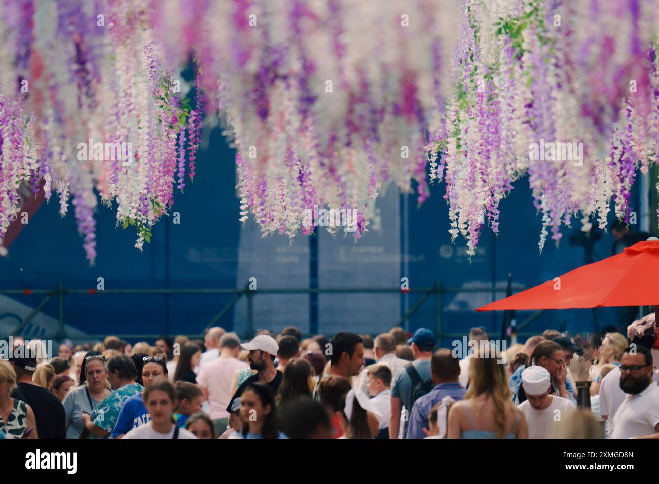 A large crowd of people enjoying an outdoor festival, with colorful ...