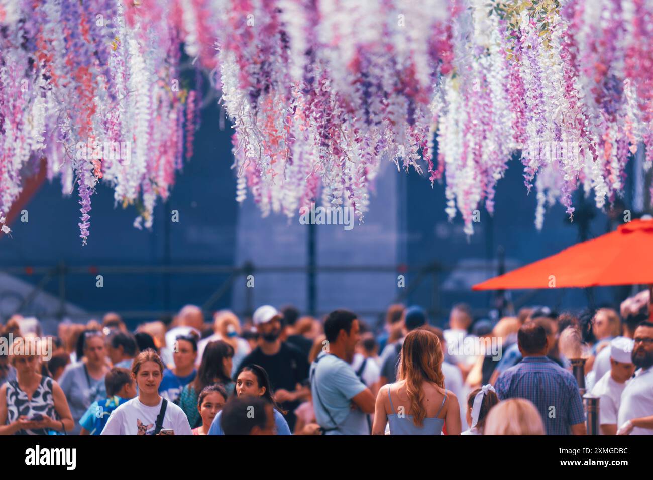A large crowd of people enjoying an outdoor festival, with colorful ...