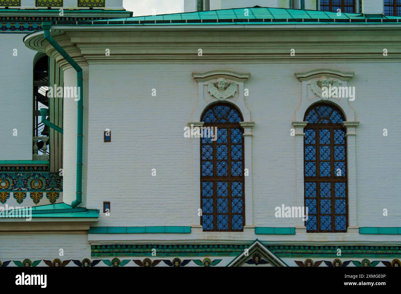 Close-up of ornate windows with intricate design elements and a green ...