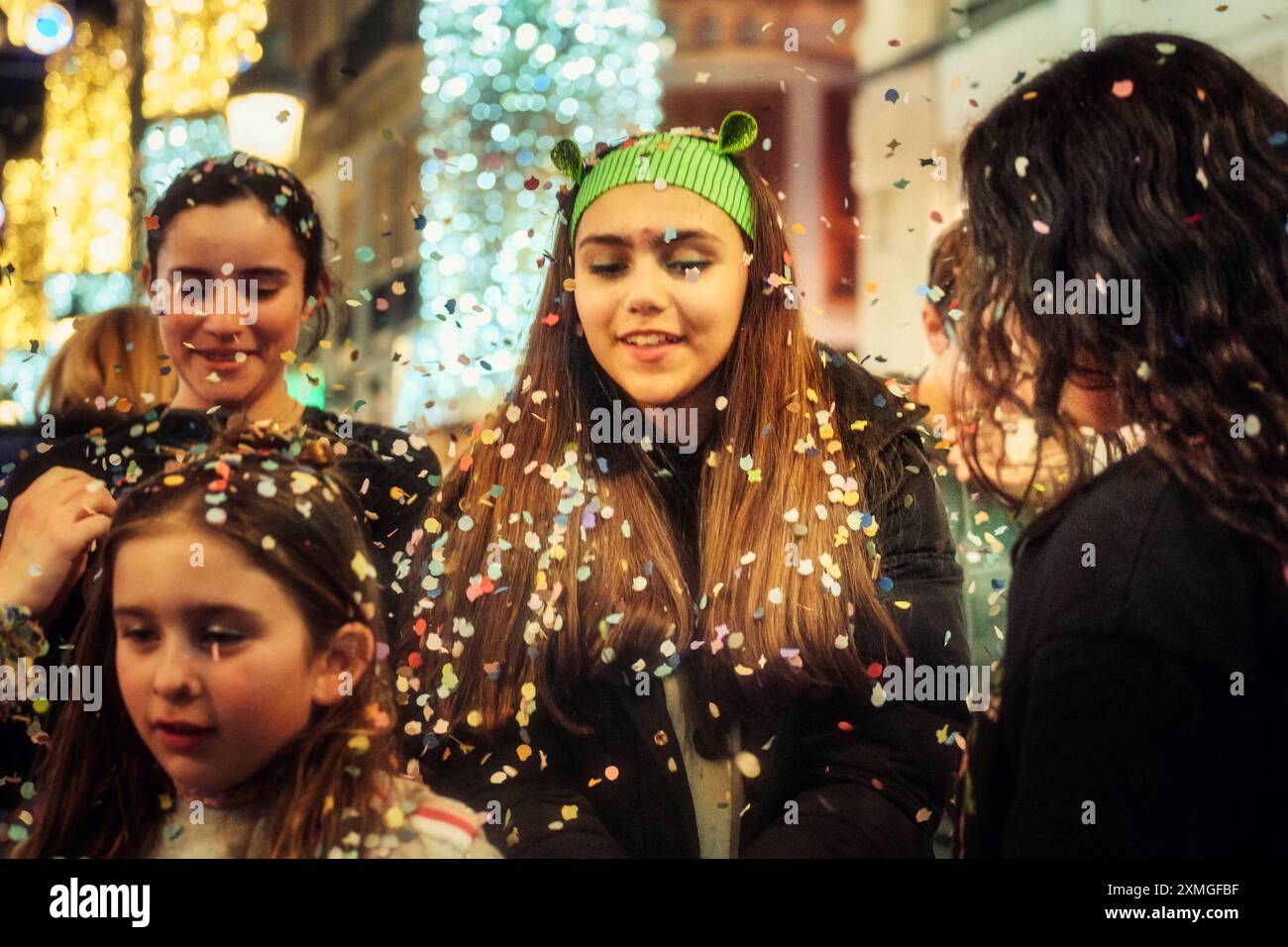 Joyful group celebrating an event with confetti amid city lights. The ...