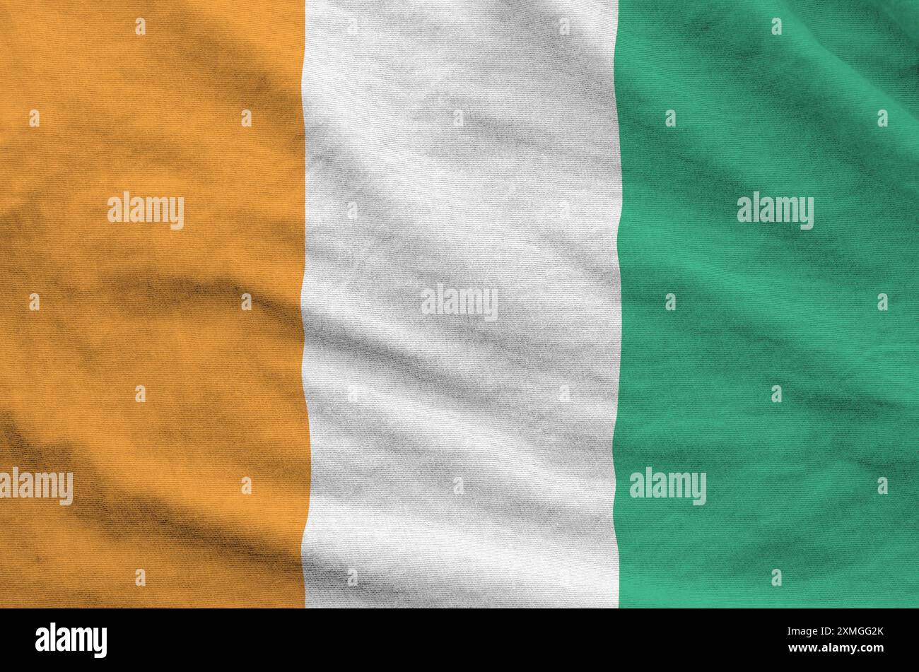 Ivory Coast flag depicted on folded wavy fabric of old cloth close up ...