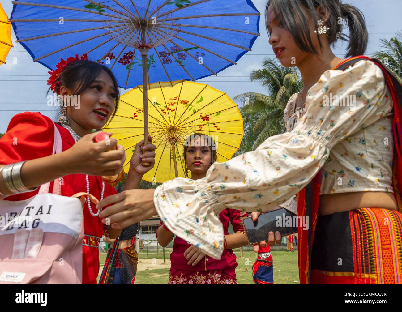 Chakma women with umbrellas in traditional clothing celebrating Biju ...