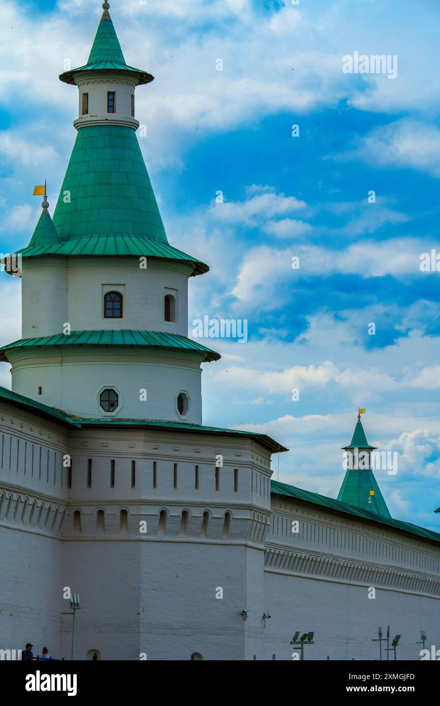 Historic monastery towers with green roofs and yellow flags under a ...
