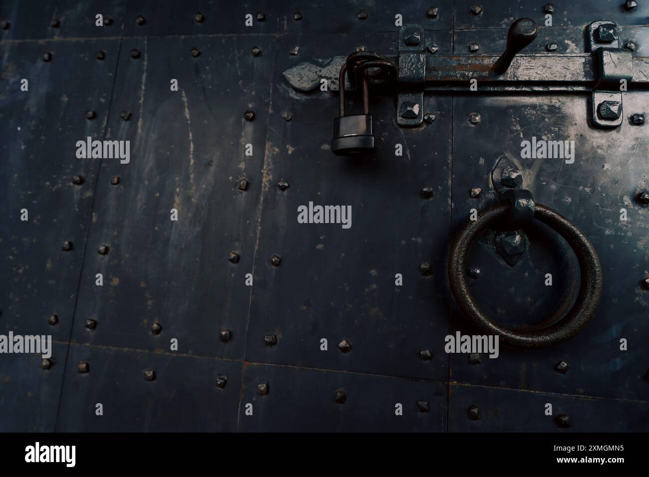 A close-up shot of a rustic metal door featuring a heavy-duty lock and ...