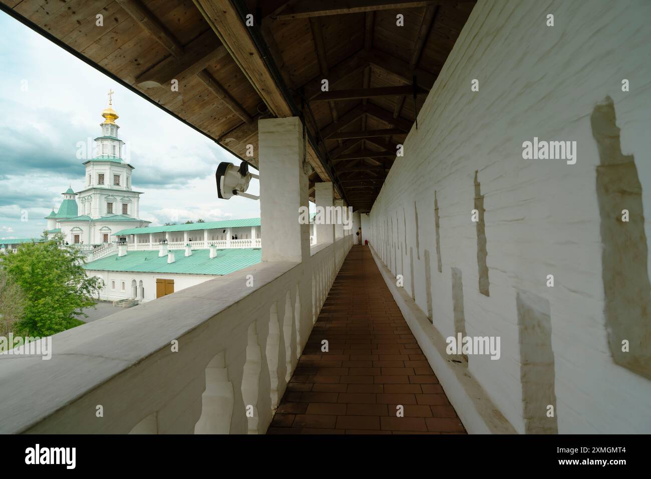 A long, covered walkway in an ancient monastery featuring arched ...