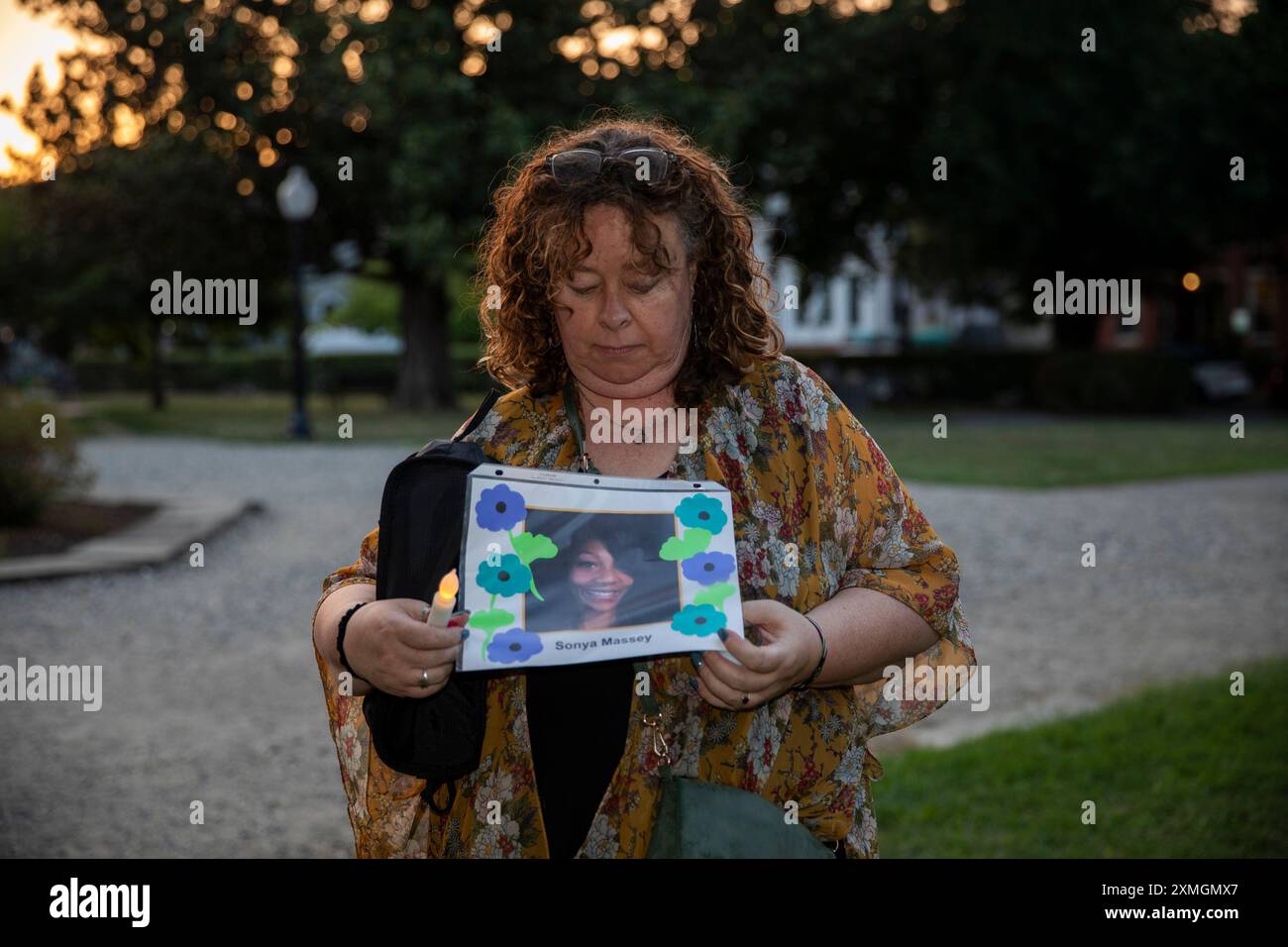 A mourner is holding Sonya Massey's picture while attending a vigil for ...