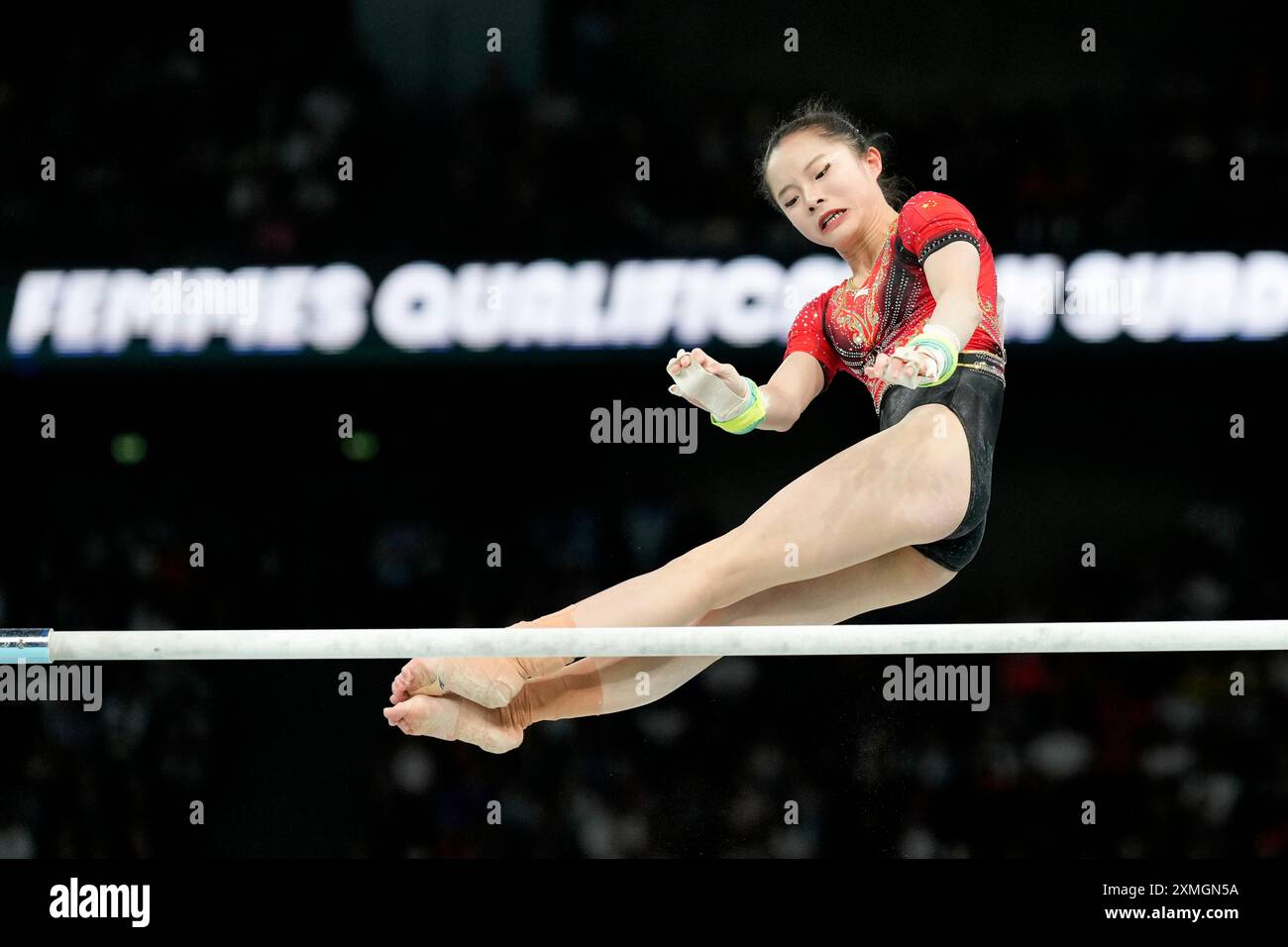 Yihan Zhang, of China, competes on the uneven bars during a women's ...