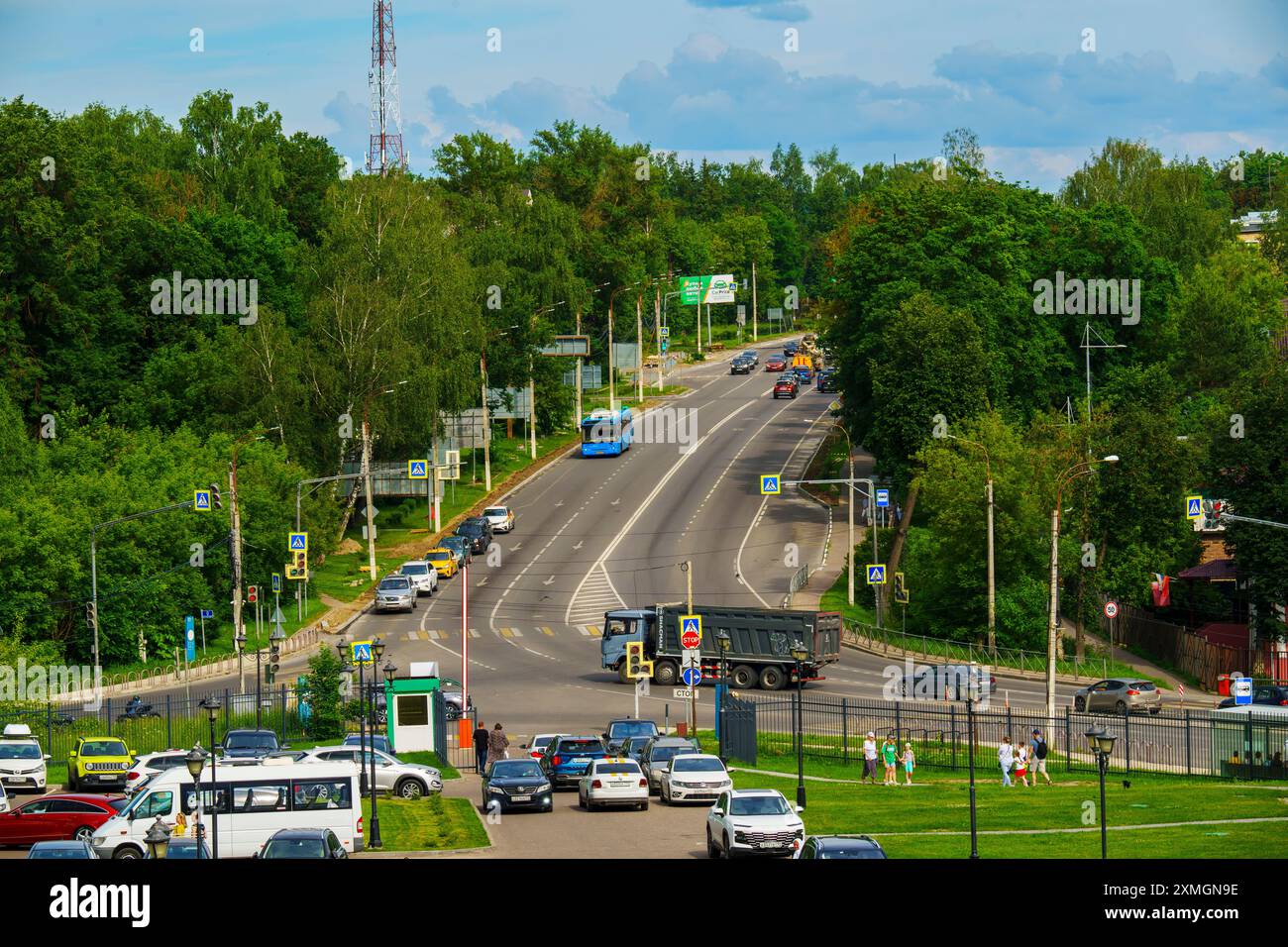 A bustling urban street with multiple vehicles including cars, buses ...