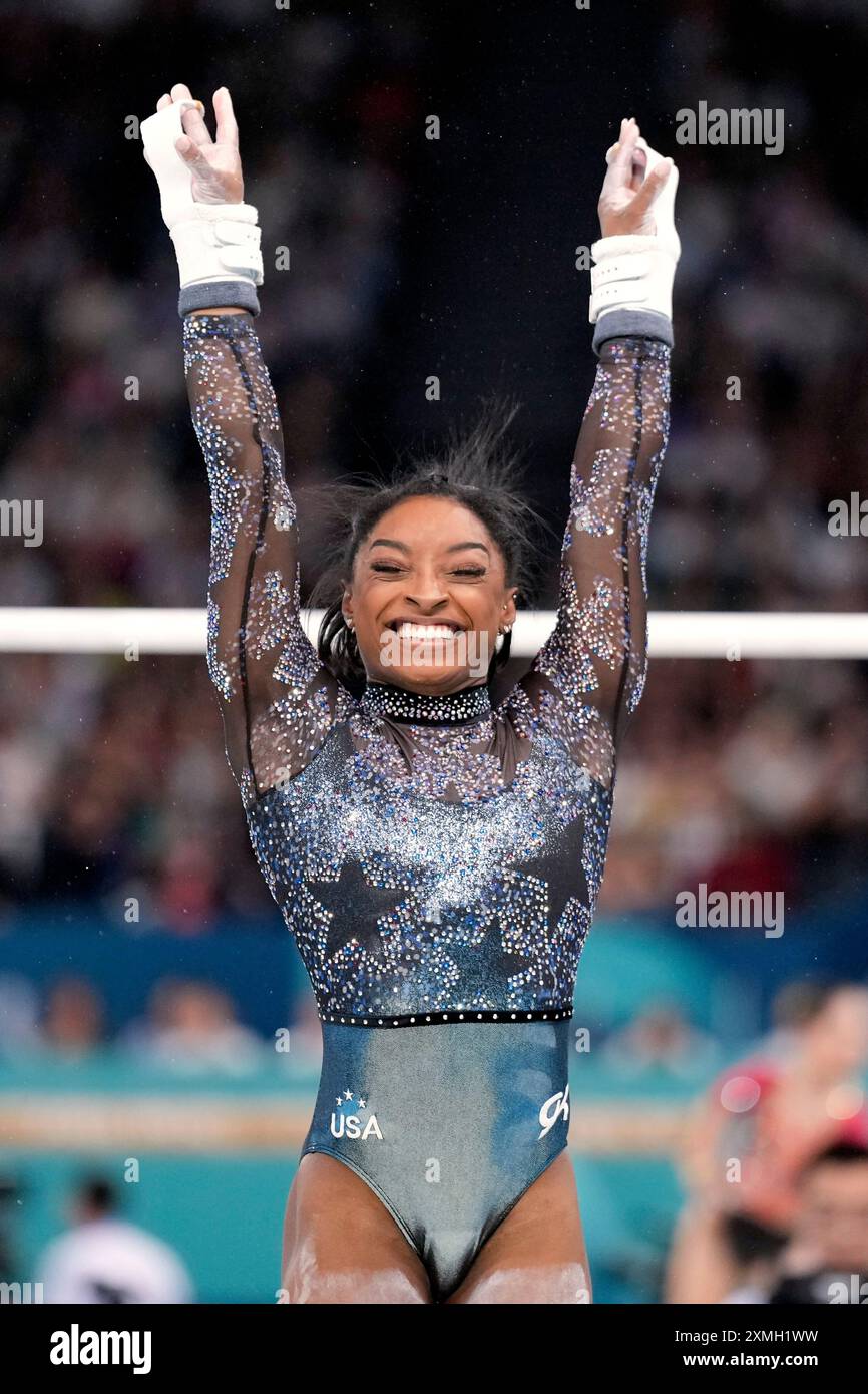 Simone Biles, of United States, smiles after competing on the uneven ...
