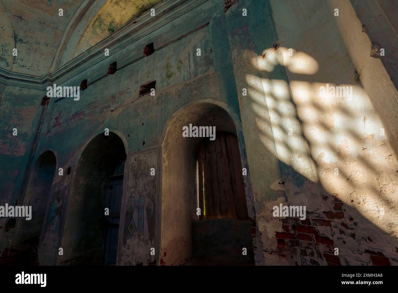 The image shows the interior of an abandoned, dilapidated church with ...