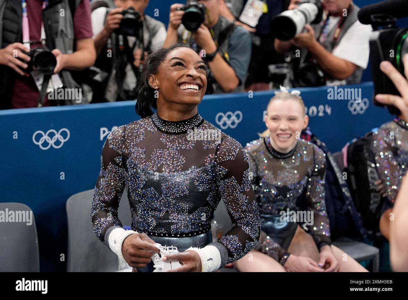 Simone Biles of United States, smiles after competing on the uneven ...