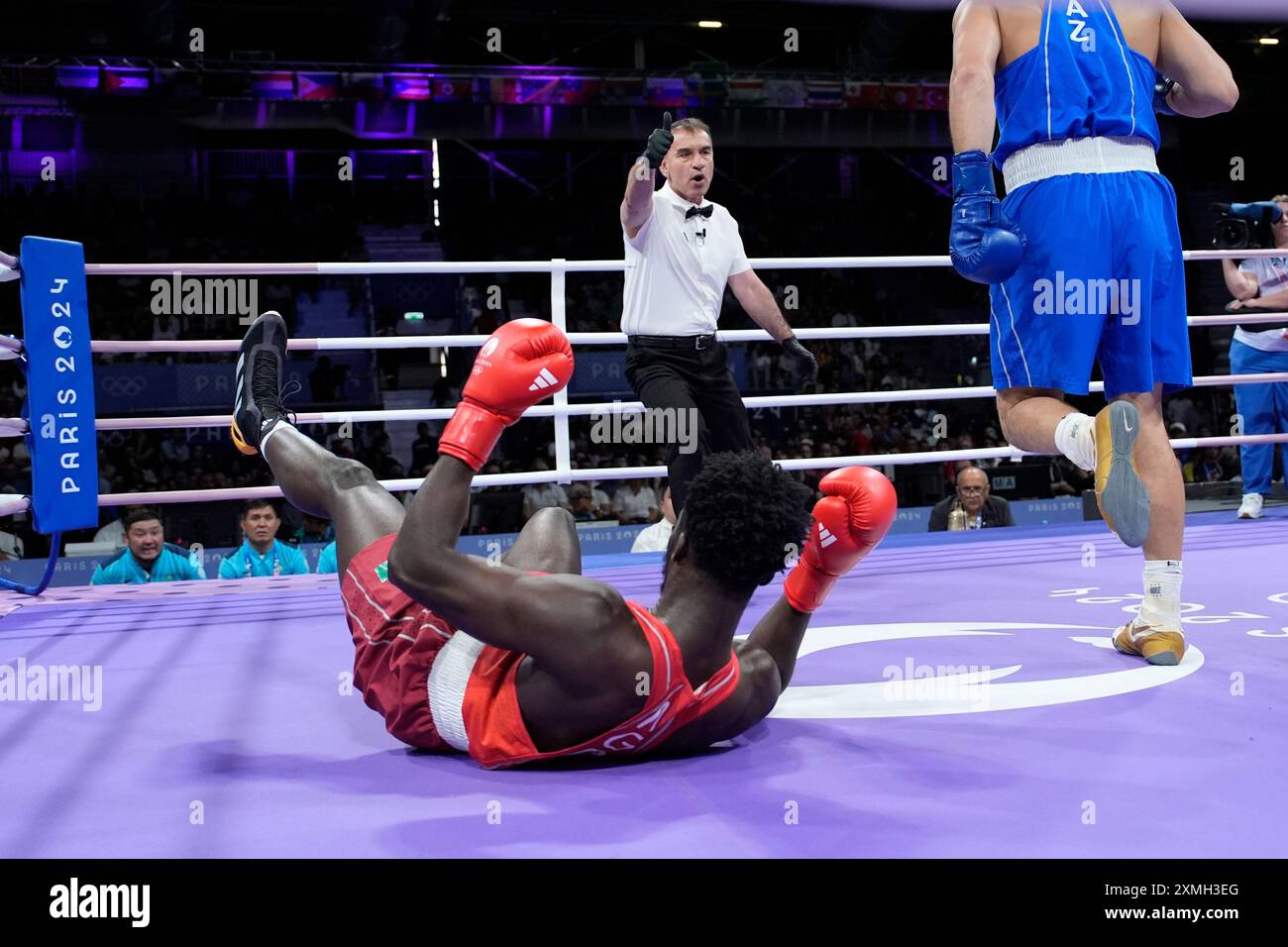 Nigeria's Olaitan Olaore, lies on the mat and Kazakhstan's Aibek ...