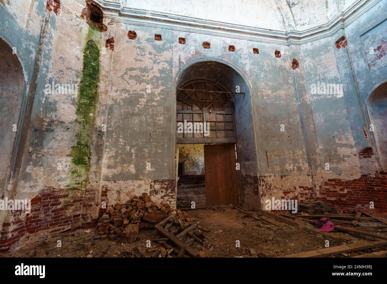The image shows the interior of an abandoned, dilapidated church with ...