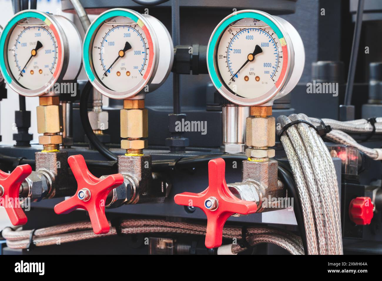 Three valves are connected to a pipe, each valve has a pressure gauge ...