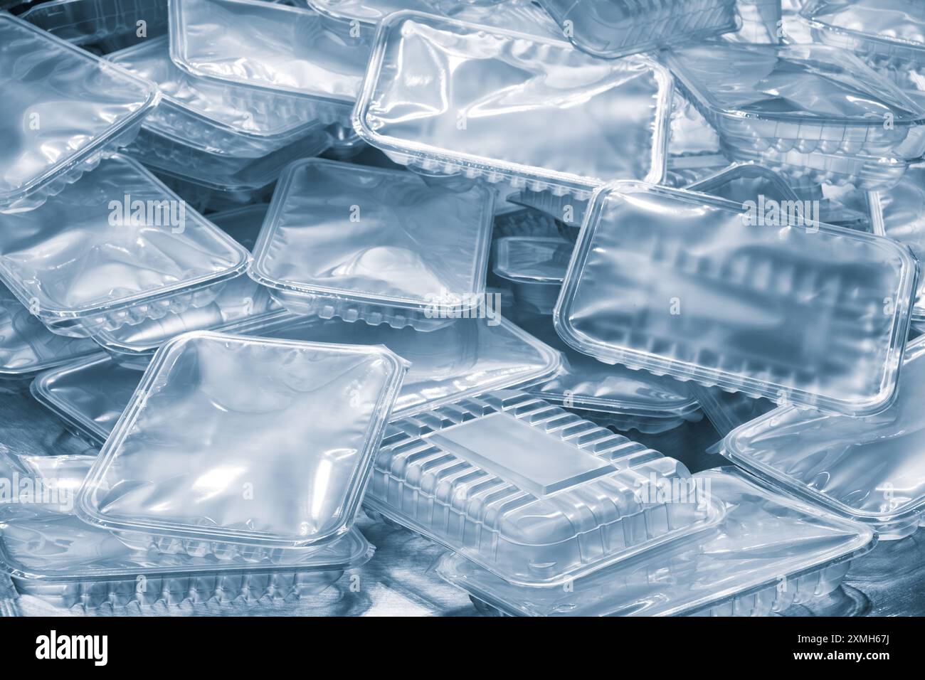 A pile of plastic containers on a blue background ready for packaging ...