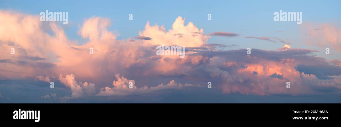 A large cloud in the sky with a pinkish hue. The sky is clear and blue ...